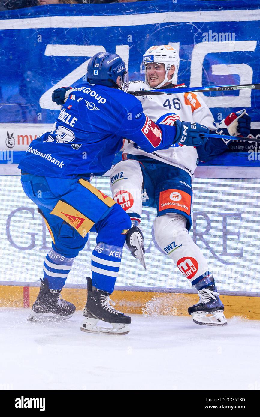Mike Kunzle #73 (EV Zug) pushes Dean Kukan #46 (ZSC Lions) against the ...