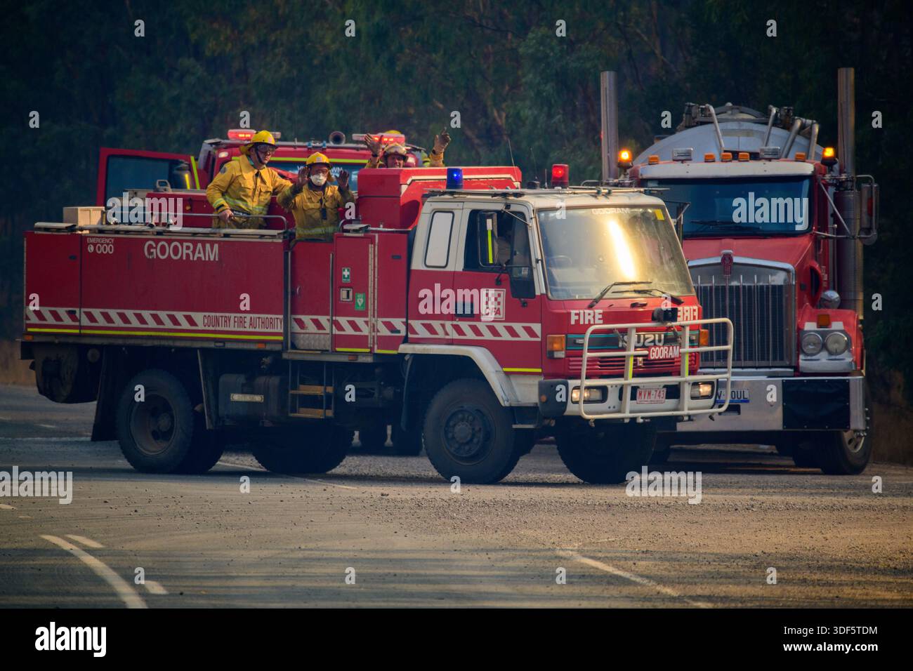 Country Fire Authority firefighters wave from a tanker near Creightons ...