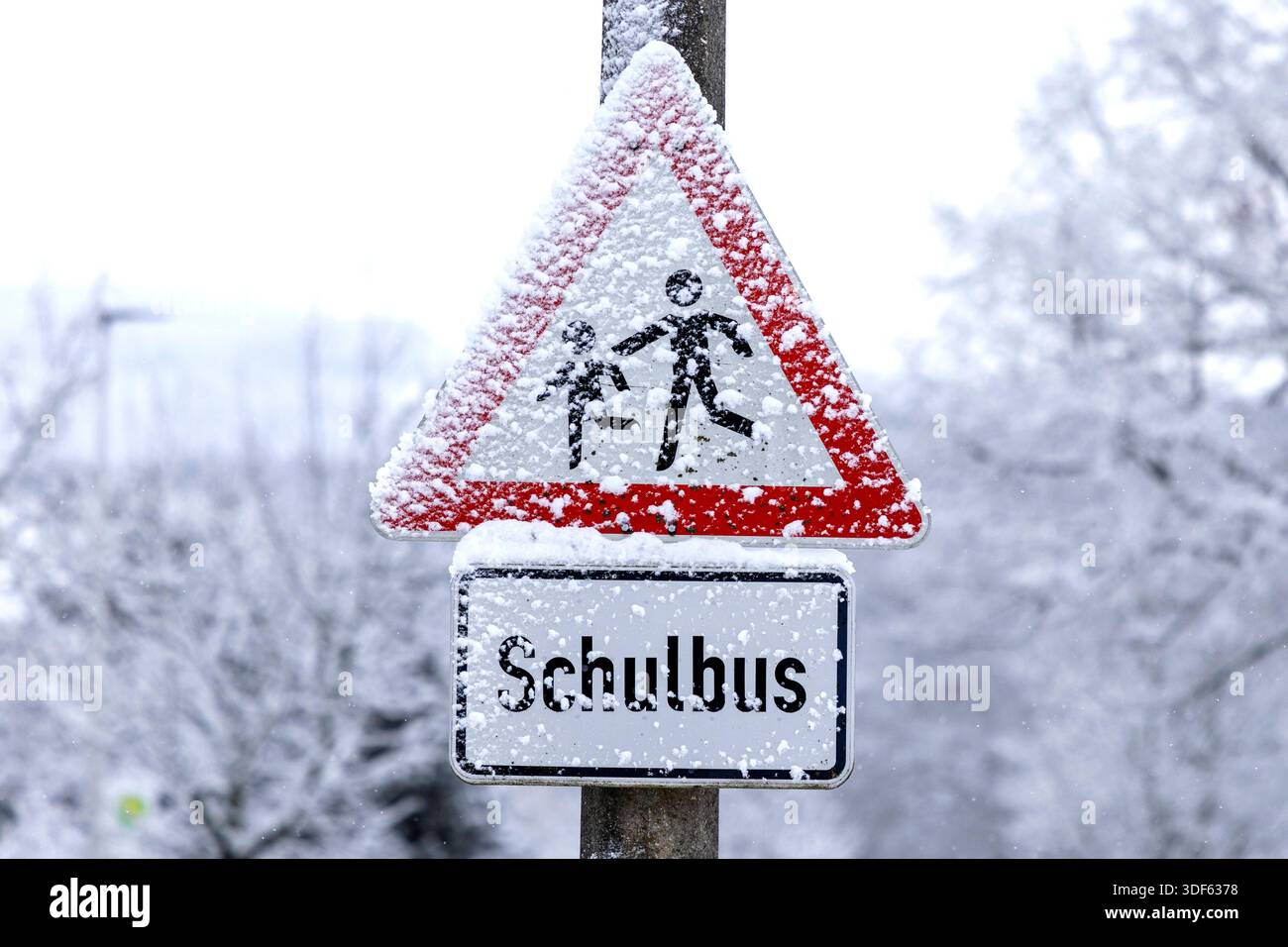 Verschneites Verkehrsschild mit dem Hinweis Schulbus vor einer ...