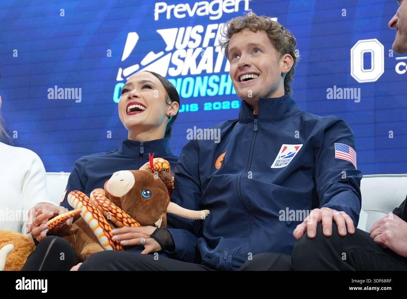 Madison Chock and Evan Bates watch for scores after finishing the free ...