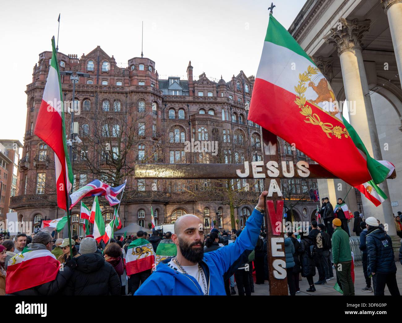 A protester holds a cross with a flag during the demonstration. A large ...
