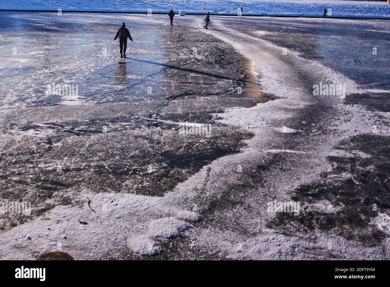 People balance over the frozen Landwehr Canal on a cold winter day in ...