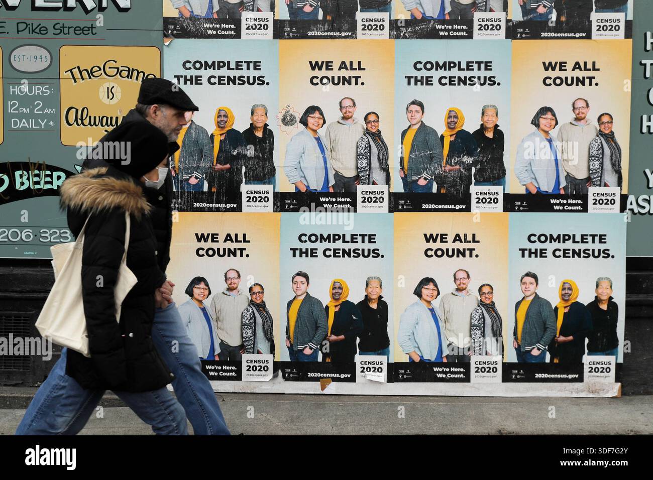 FILE - People walk past posters encouraging participation in the 2020 ...