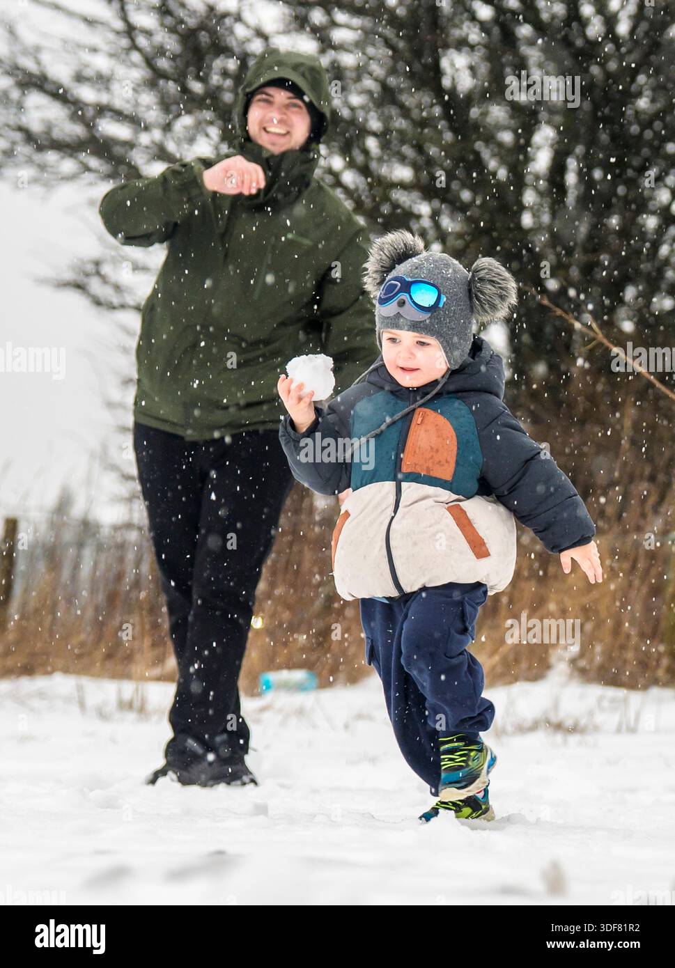 Jordan Biggs and his son Dominic Biggs, play in the snow near ...