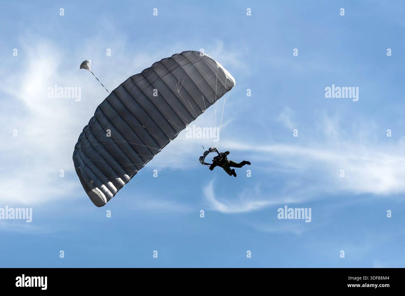 Skydiver maneuvers at low altitude as he approaches the landing zone ...