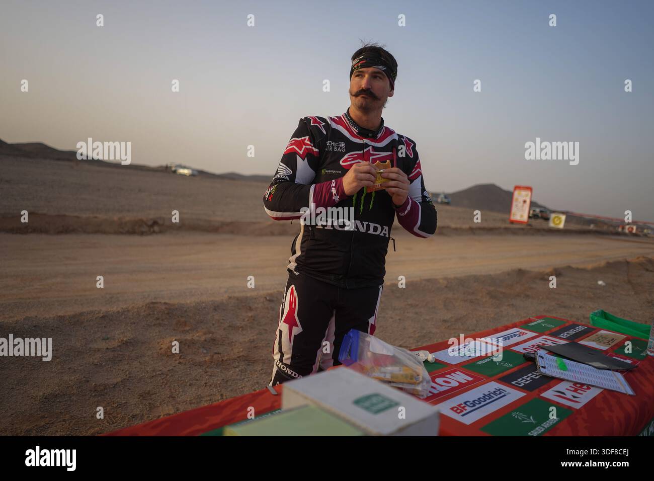 Rider Skyler Howes eats a biscuit before the start of the seventh stage ...