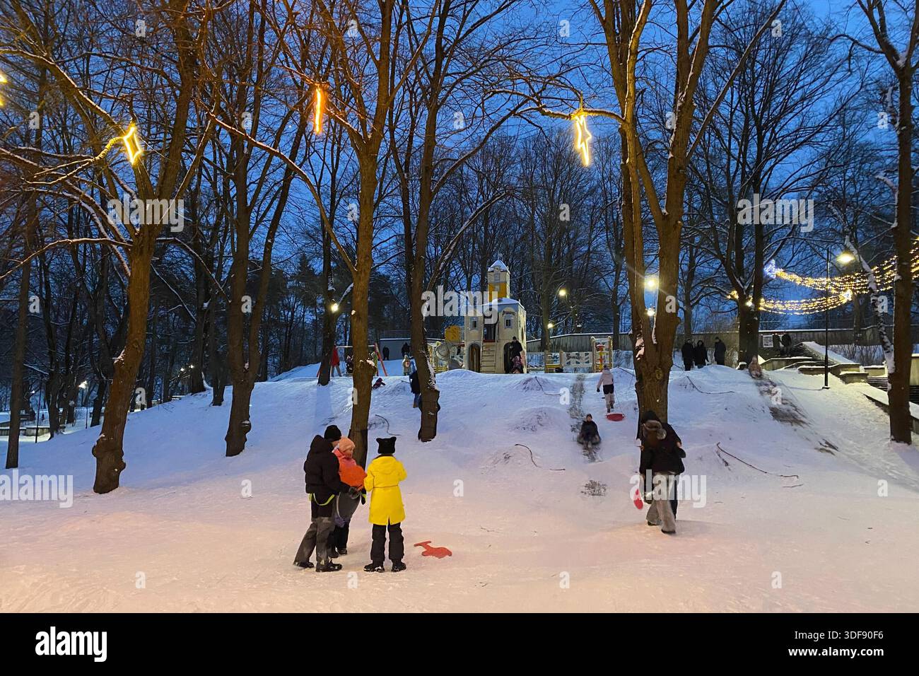 11 January 2026, Latvia, Riga: People ride down the hill on sledges at ...