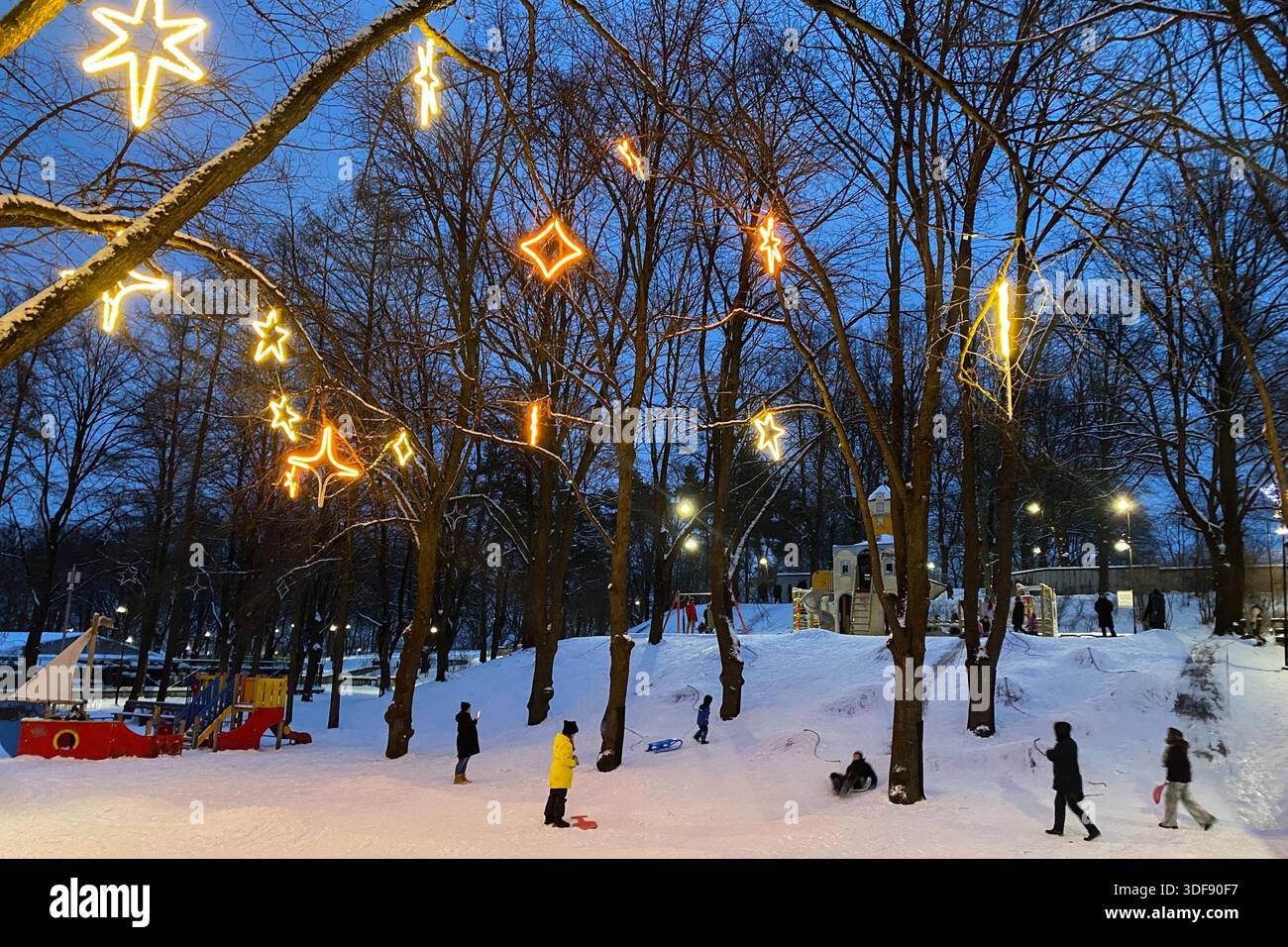 11 January 2026, Latvia, Riga: People ride down the hill on sledges at ...