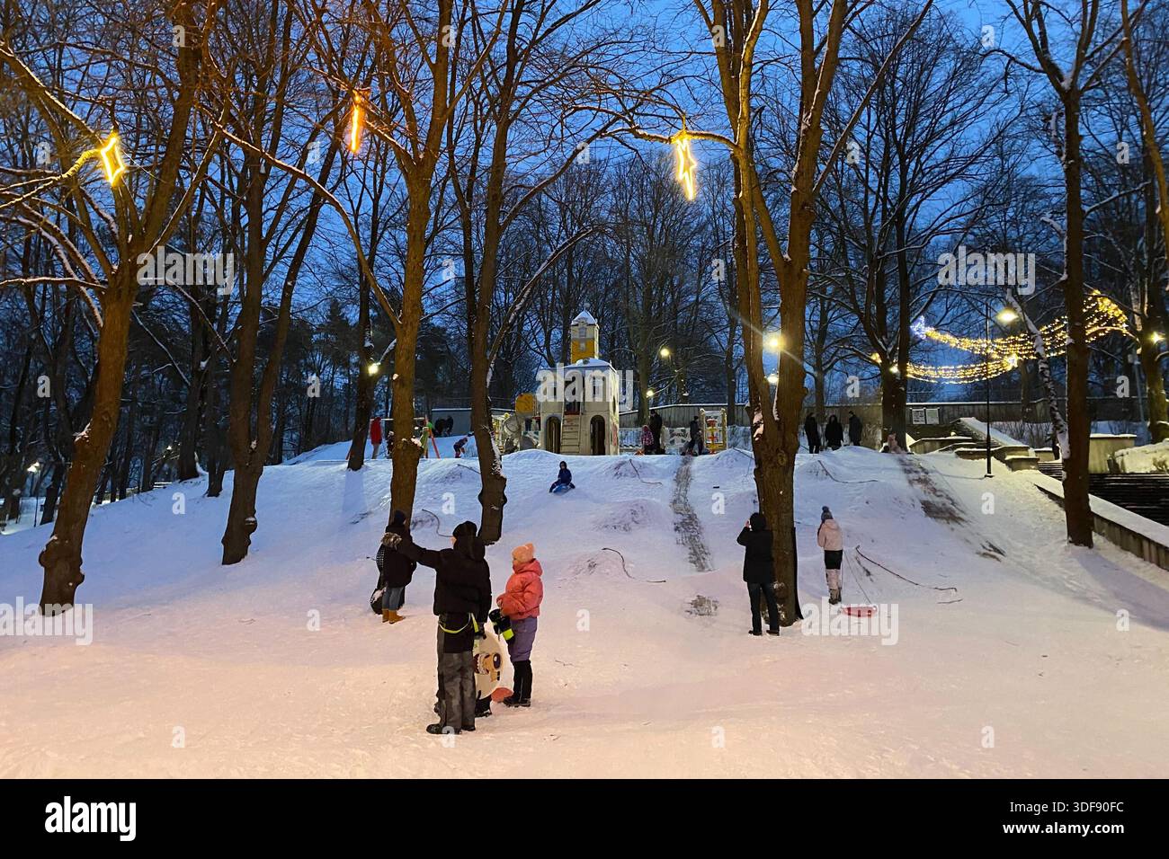 11 January 2026, Latvia, Riga: People ride down the hill on sledges at ...
