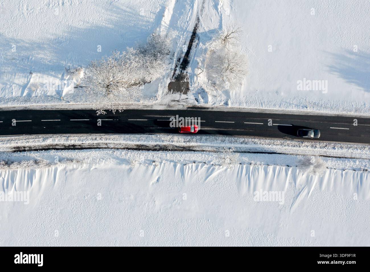 11 January 2026, Lower Saxony, Wiefels: Two cars driving on a road ...