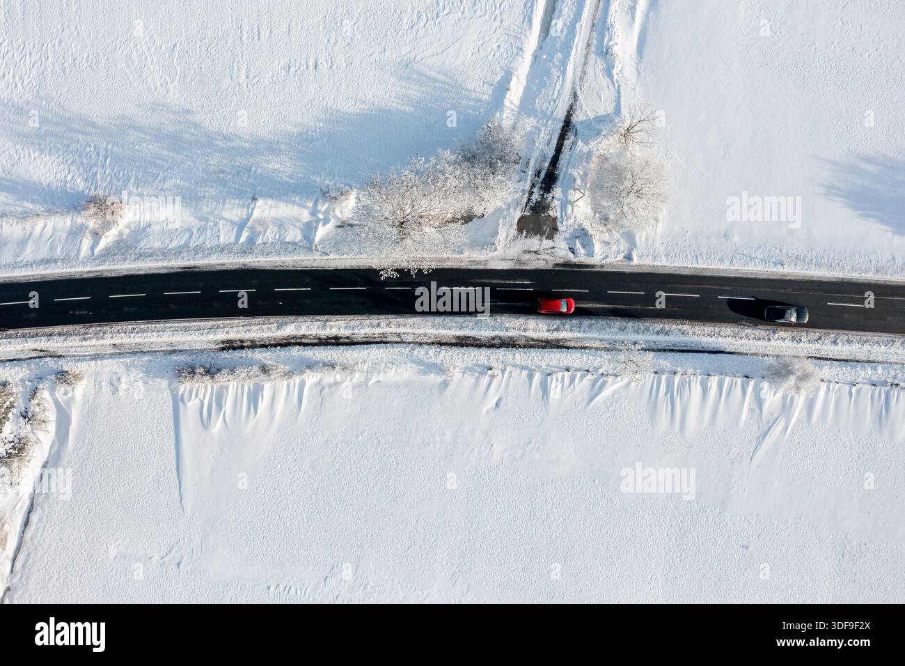 11 January 2026, Lower Saxony, Wiefels: Two cars driving on a road ...