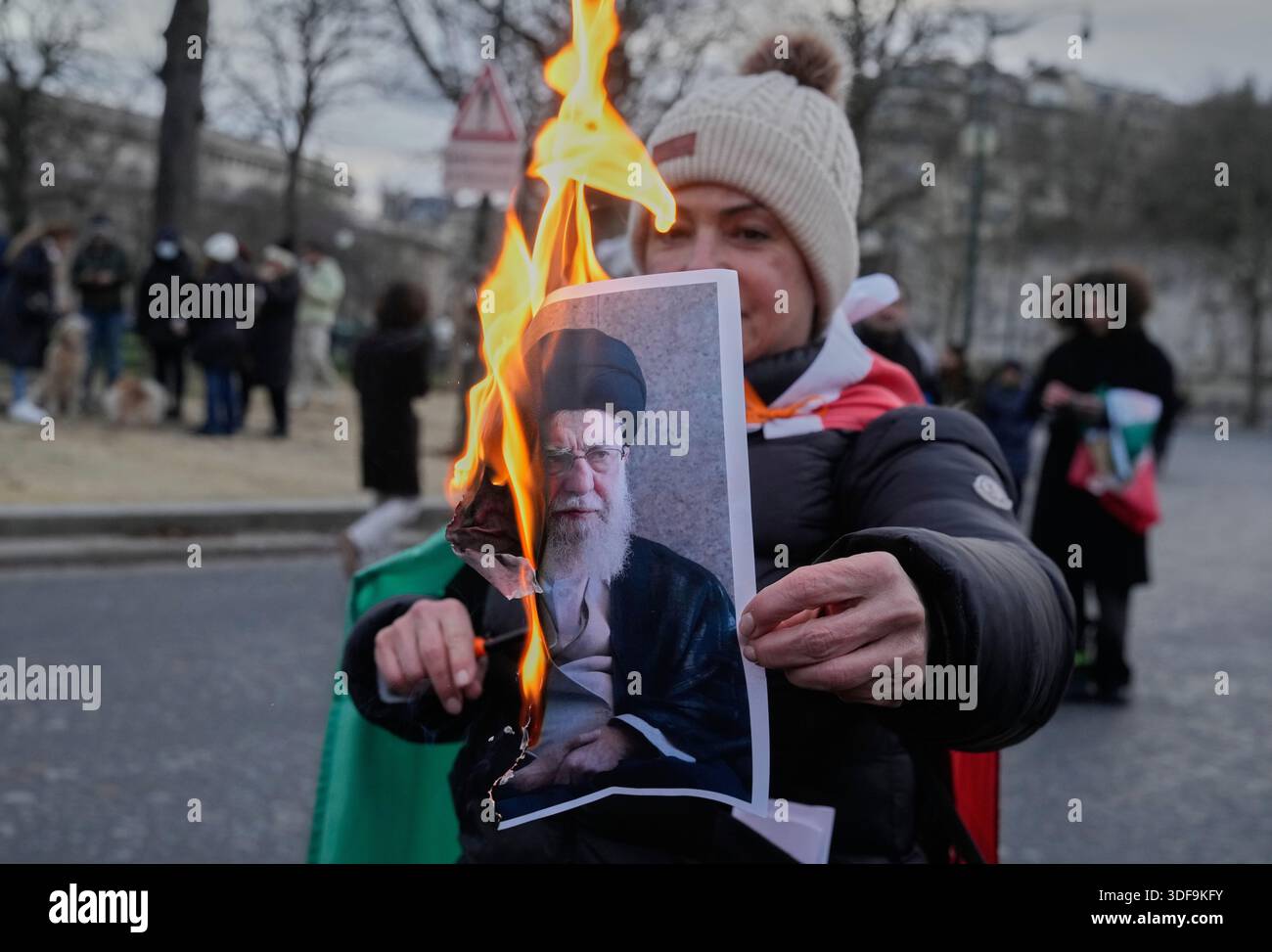 A protester holds a burning poster of Iran's Supreme Leader Ayatollah ...