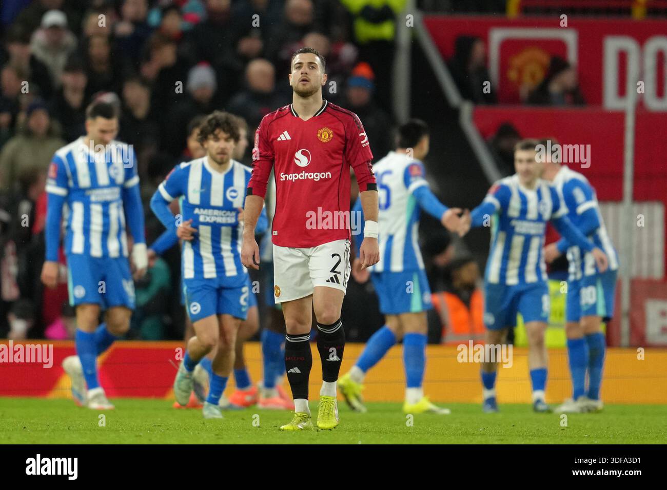 Manchester United's Diogo Dalot walks to the center as Brighton players ...