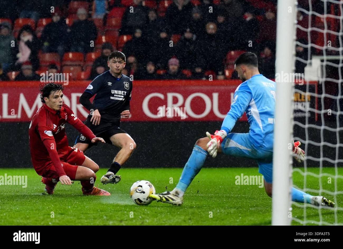 Rangers' Mikey Moore (centre) sees his shot at goal saved by Aberdeen ...