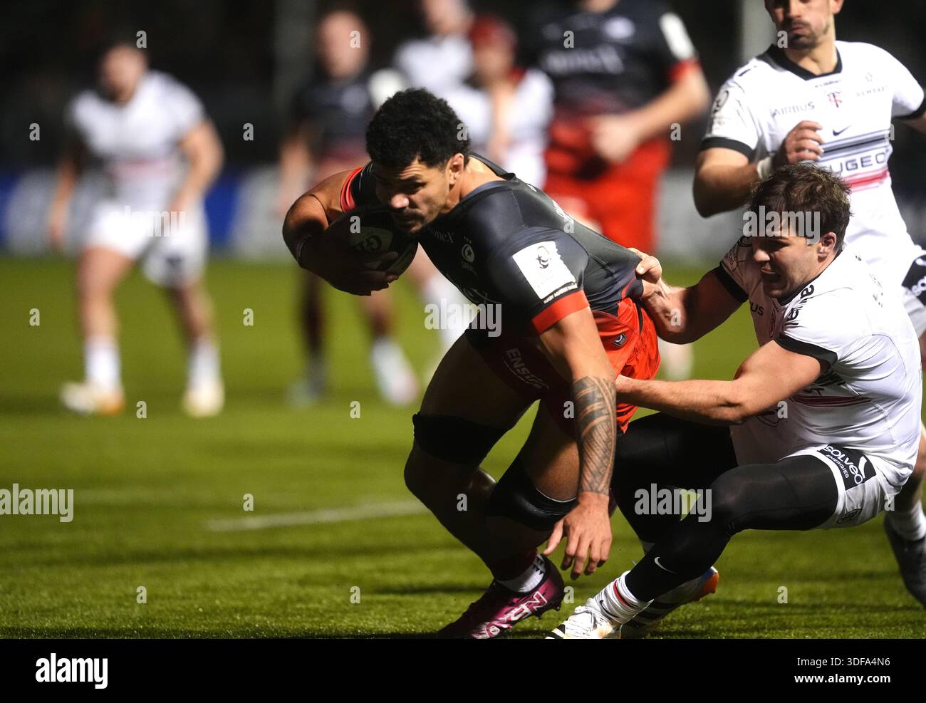Saracens' Theo McFarland is tackled by Stade Toulousain's Antoine ...