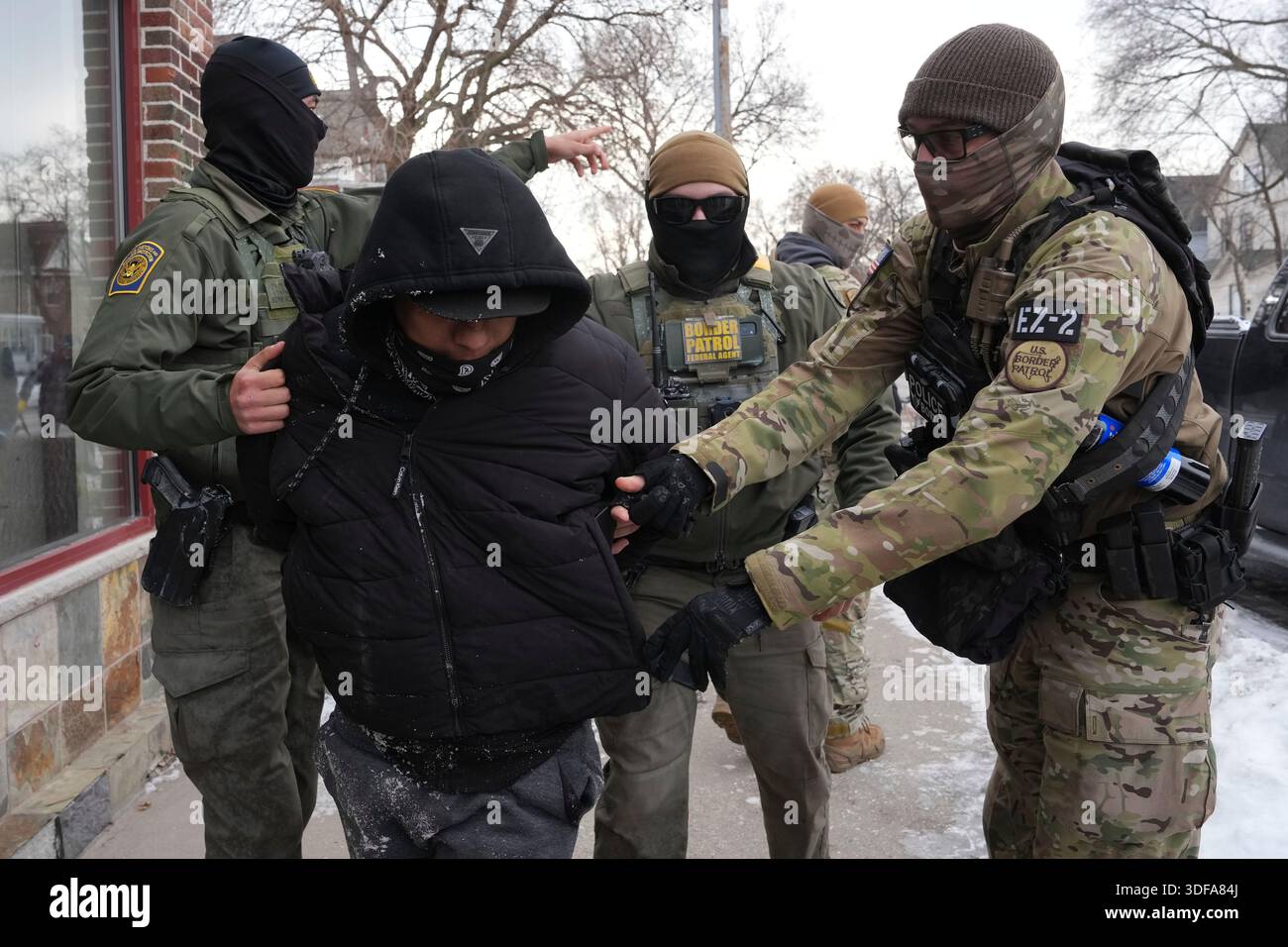 Border Patrol agents detain a man, Sunday, Jan. 11, 2026, in ...