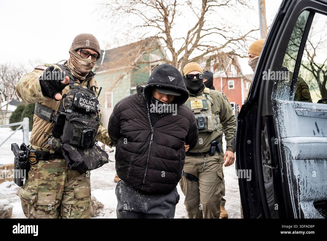 Federal agents detain a person in Minneapolis, Minn., on Sunday, Jan ...