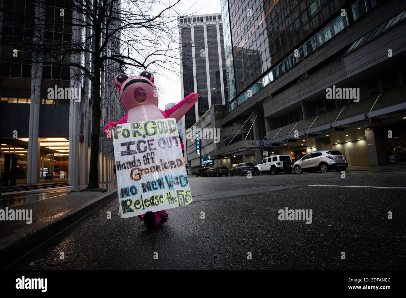 A person wearing an inflatable pink frog costume waves at oncoming ...