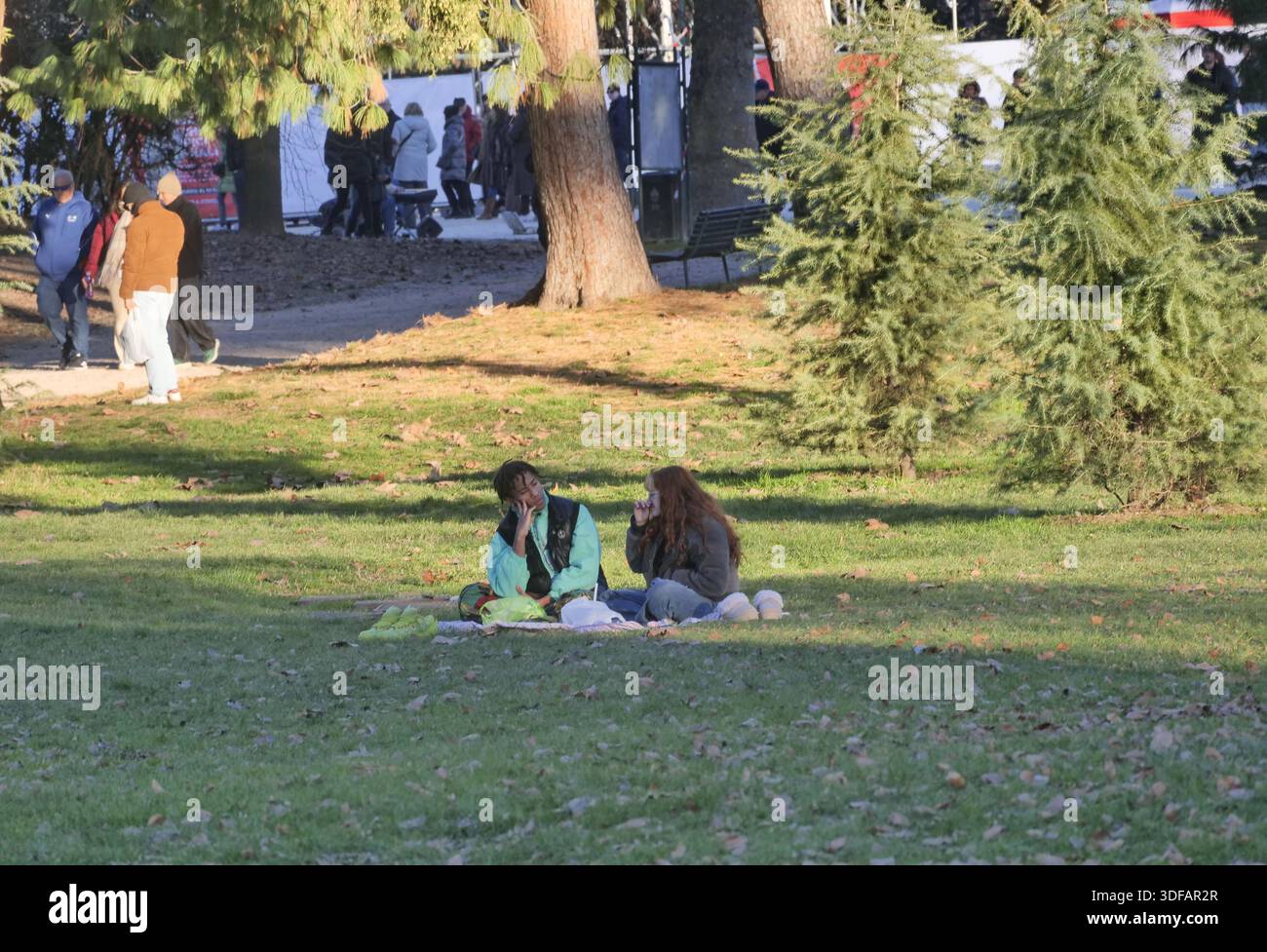 Many people in public parks on lawns and benches enjoying the beautiful ...