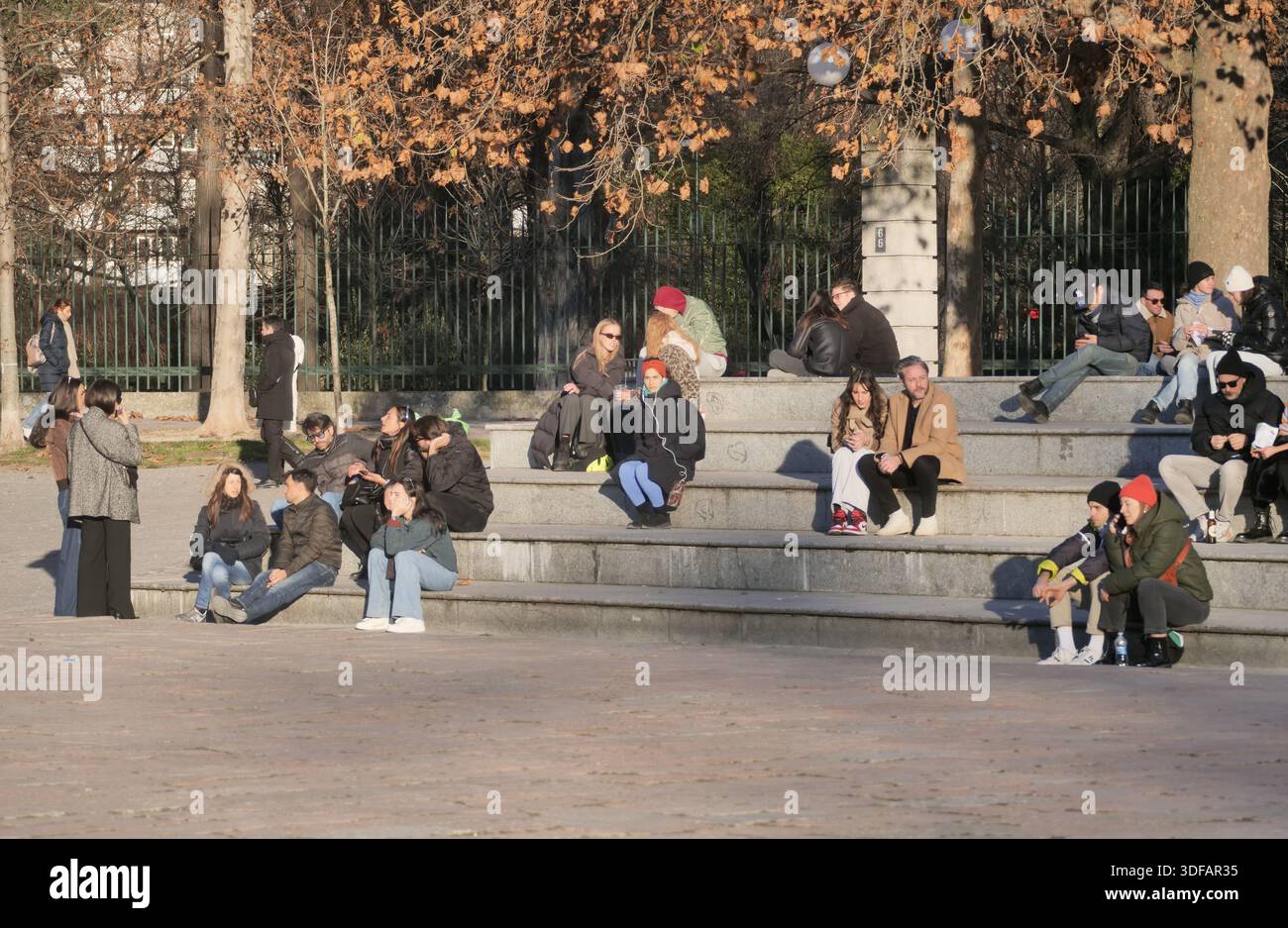 Many people in public parks on lawns and benches enjoying the beautiful ...