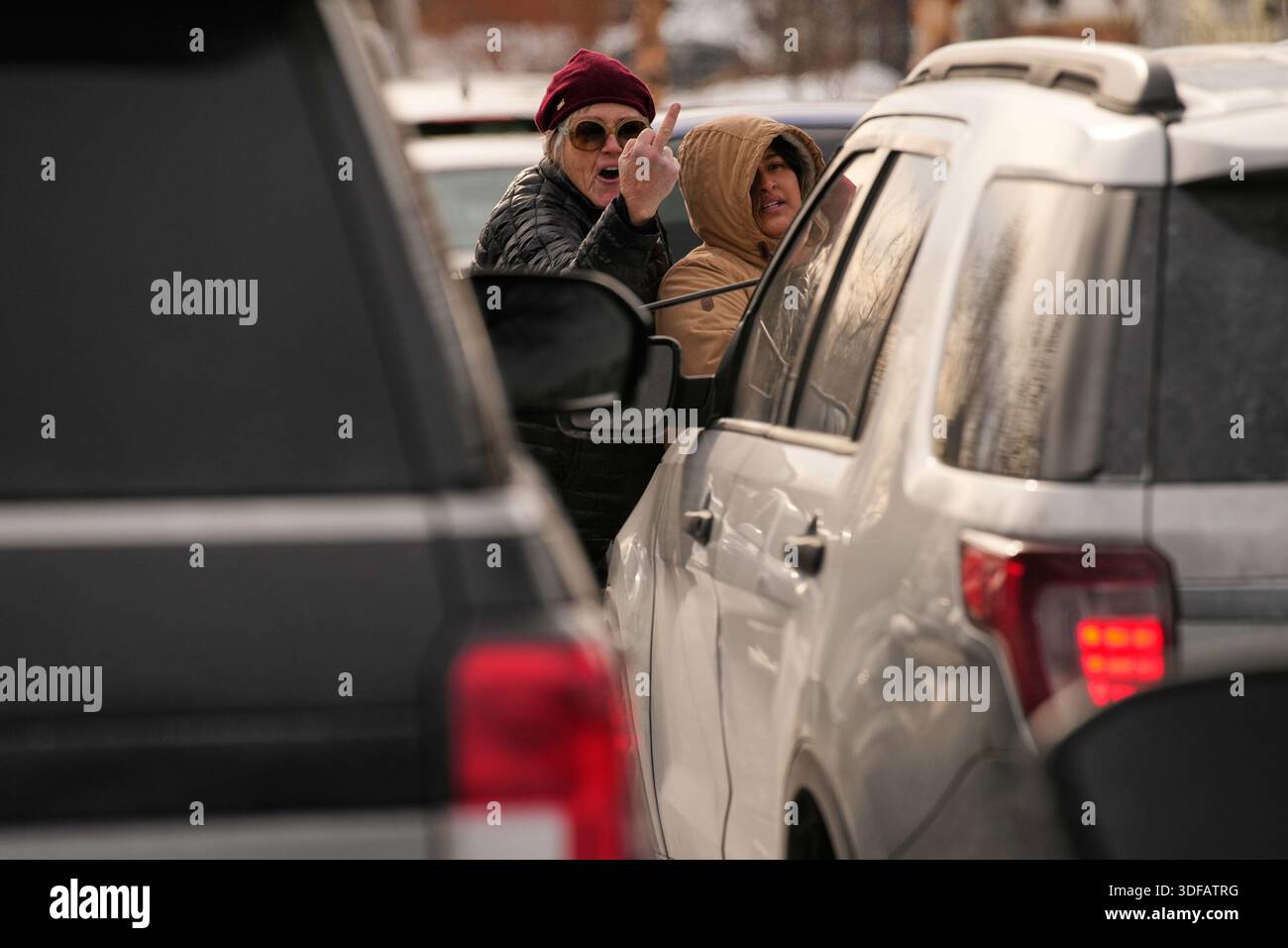 EDS NOTE: OBSCENITY - A woman gestures at federal immigration officers ...