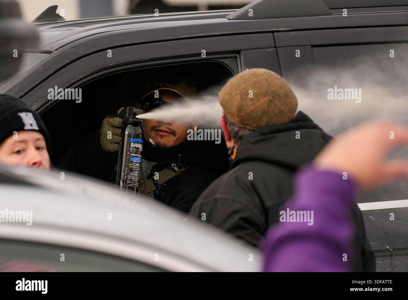 A federal immigration officer deploys pepper spray as officers make an ...