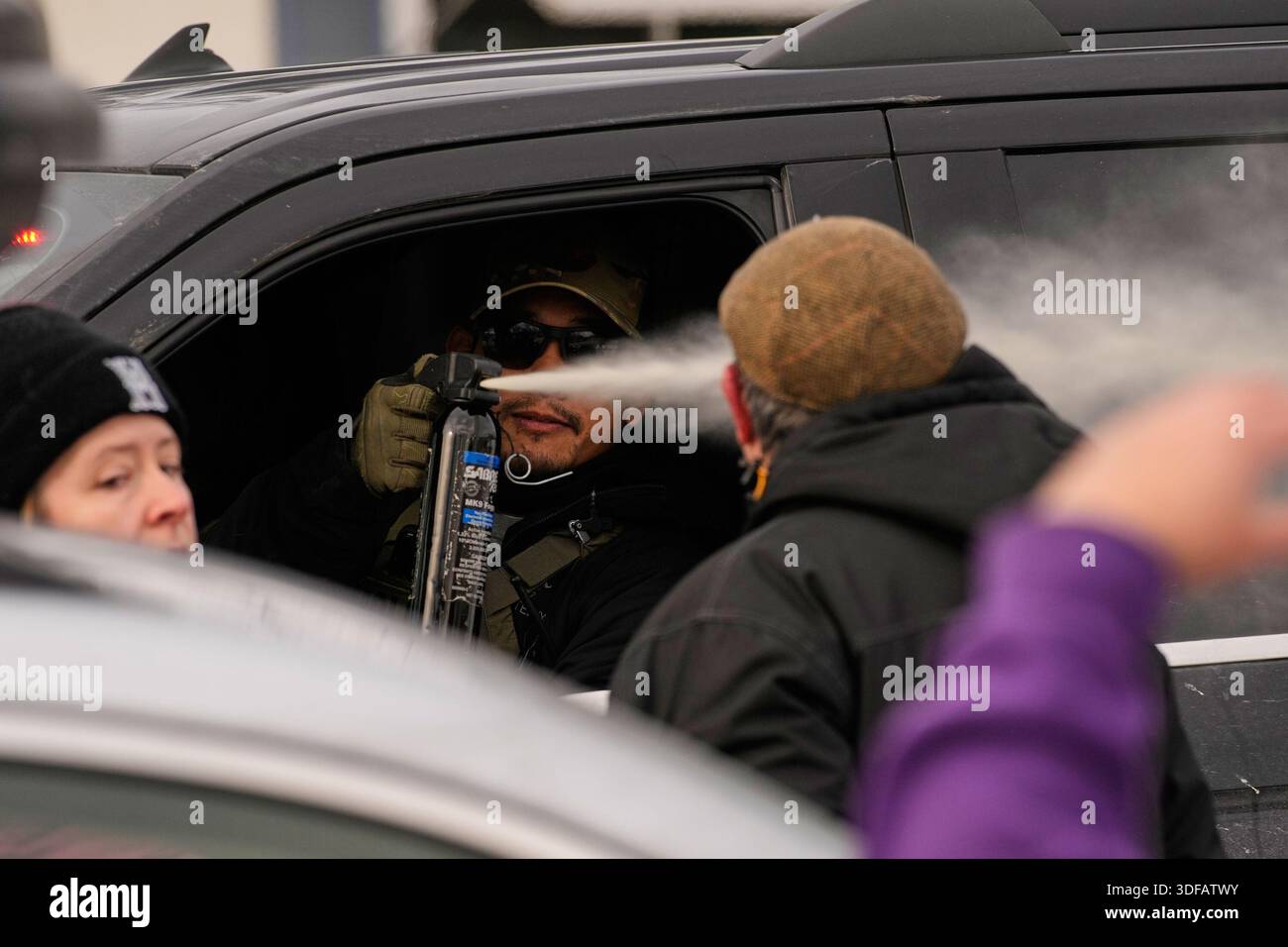 A federal immigration officer deploys pepper spray as officers make an ...