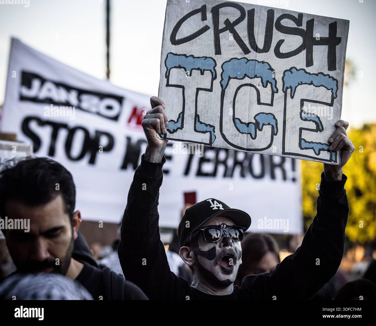 A protester raises a hand-painted sign reading “Crush ICE” during an ...