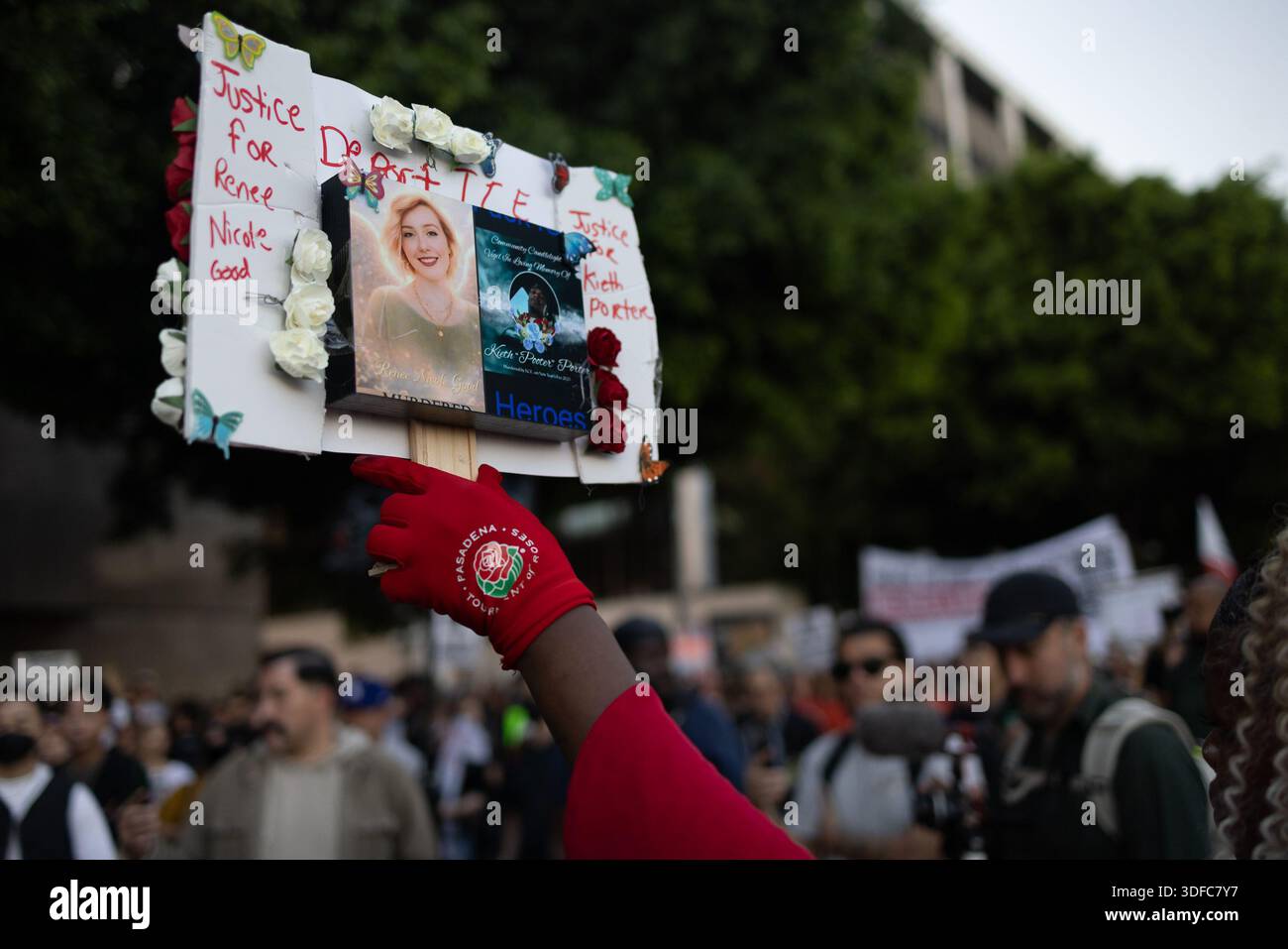 A handmade memorial sign honoring Renee Nicole Good is raised during ...