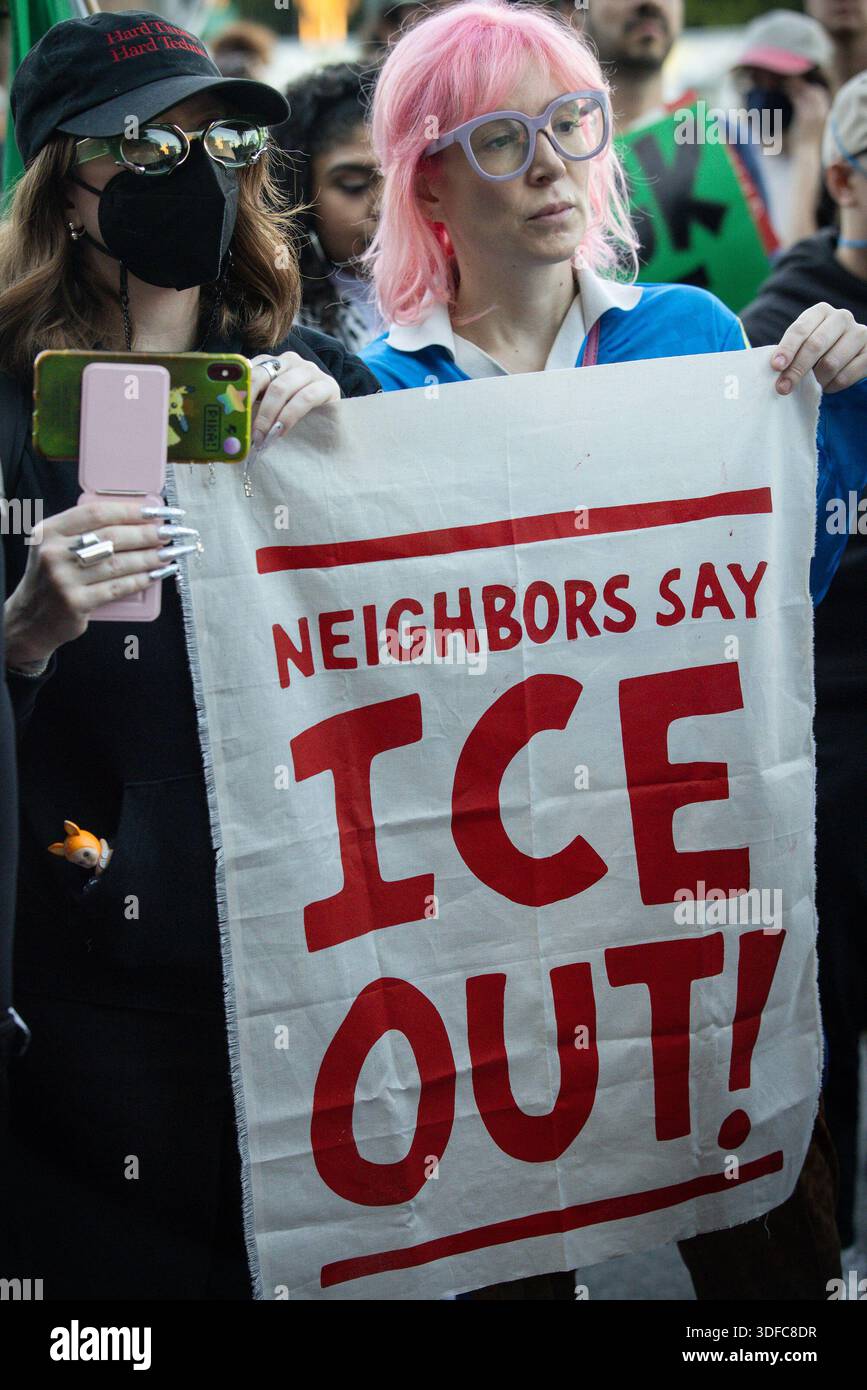 Protesters hold a banner reading “Neighbors Say ICE Out” during an ICE ...