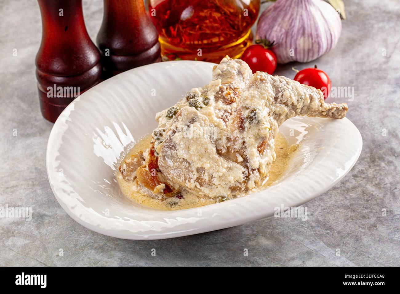 Roasted rabbit legs in cream sauce with capers Stock Photo - Alamy