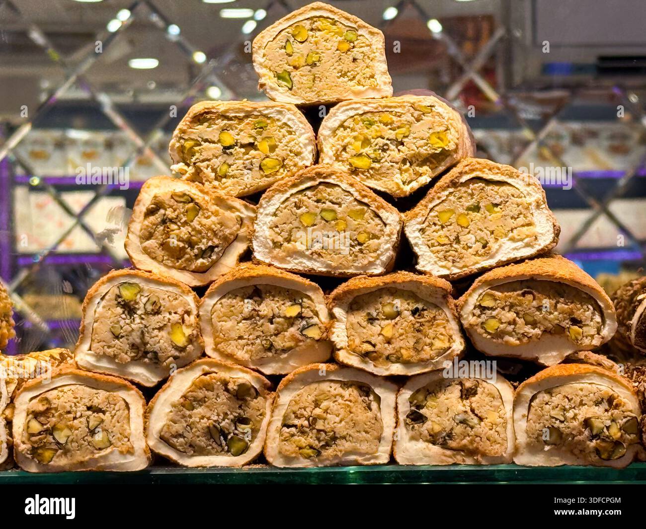 Pistachio filled nougat rolls coated in green crumbs stacked in a ...