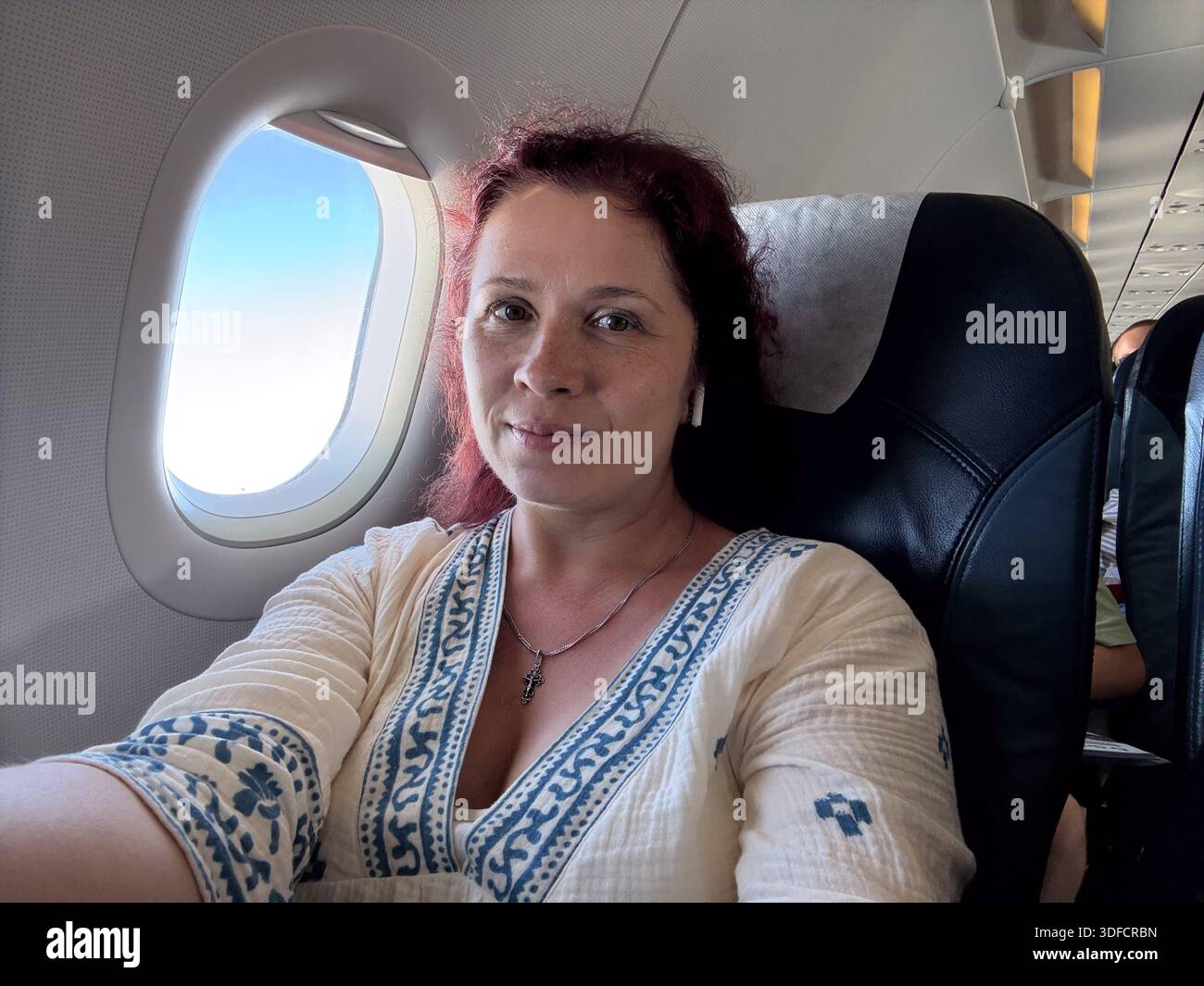 Passenger woman looking through airplane window during flight. Travel ...