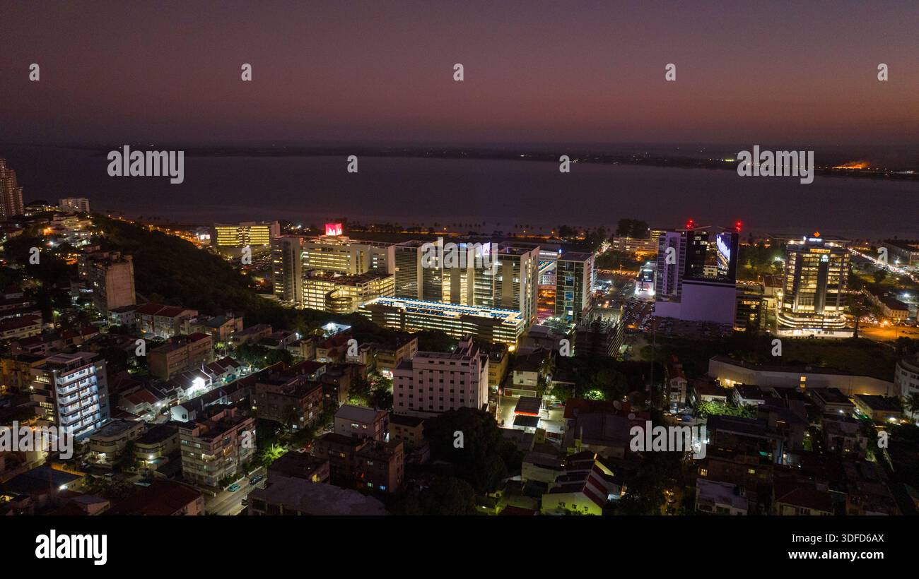 Aerial view of a modern cityscape glowing with warm light against the ...