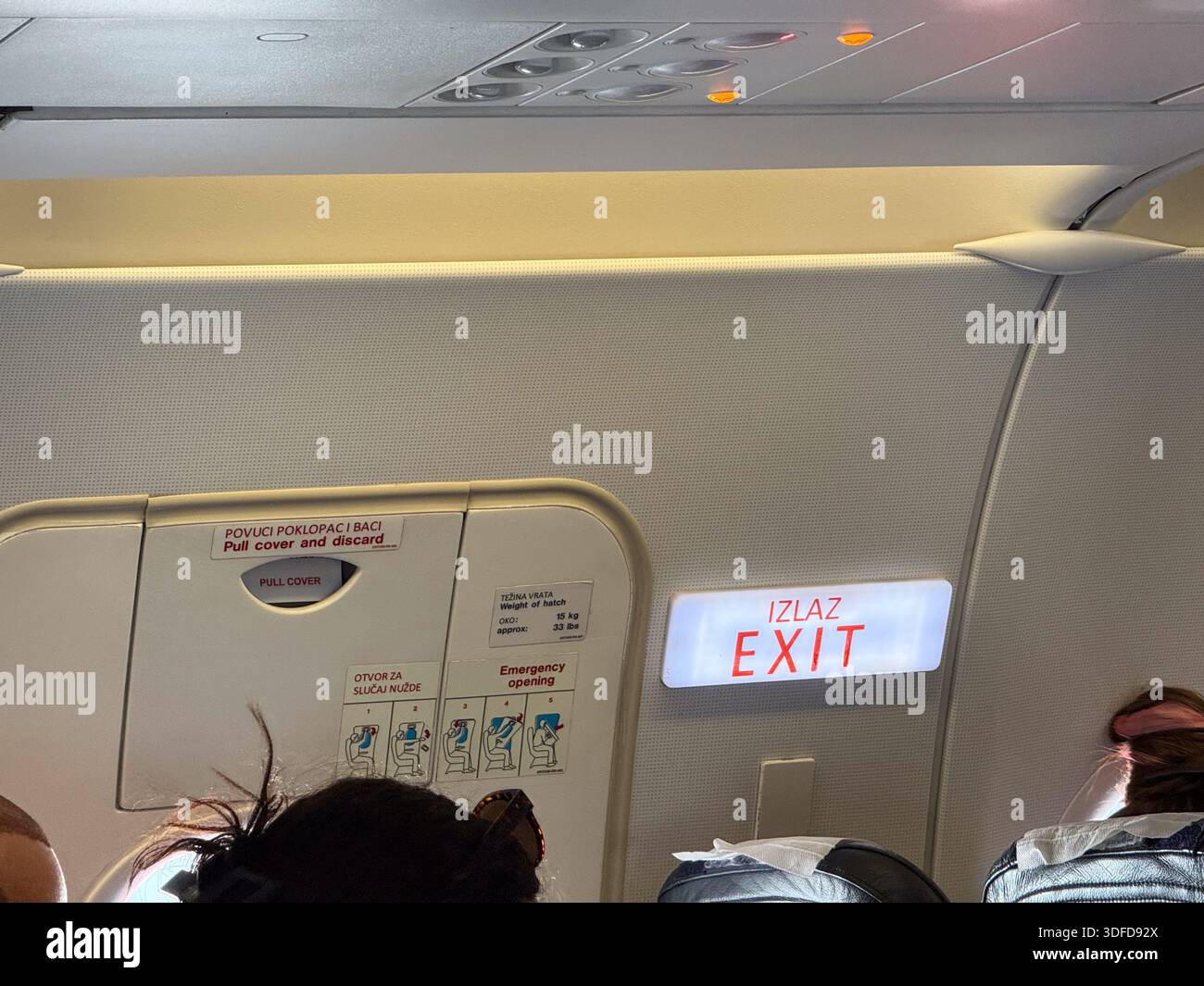 Airplane emergency exit door and illuminated sign inside passenger ...