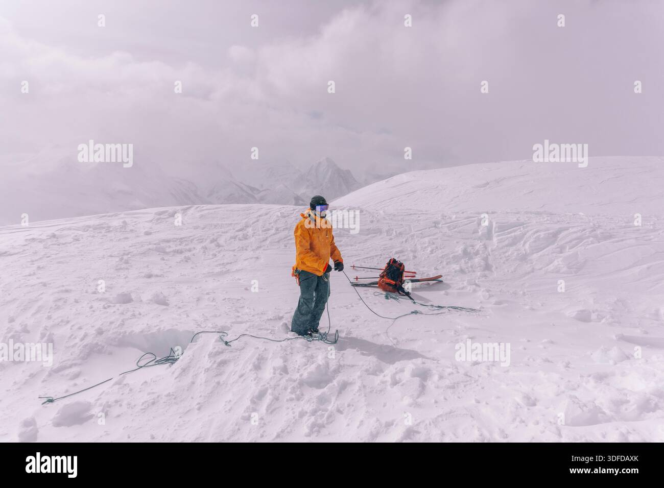 A ski guide stands in the snow on a glacier in the Northern Rockies of ...
