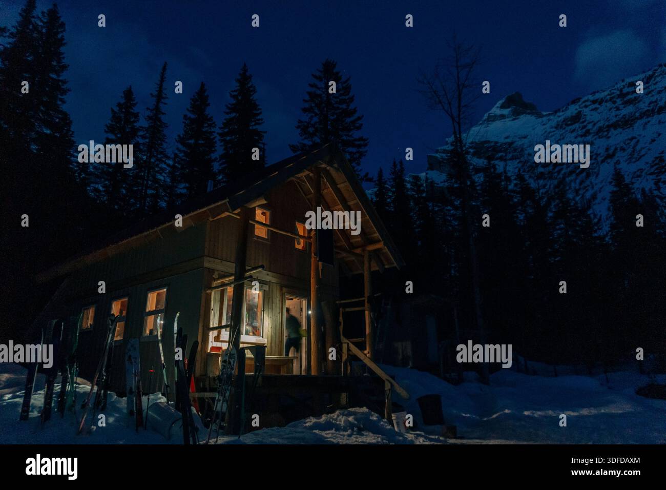 A man walks into a backcountry hut at night in the Northern Rockies of ...