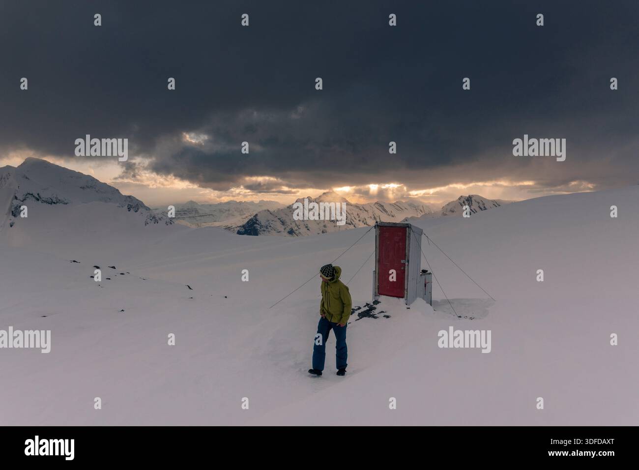 A man walks in front of an outhouse at a backcountry hut in the ...