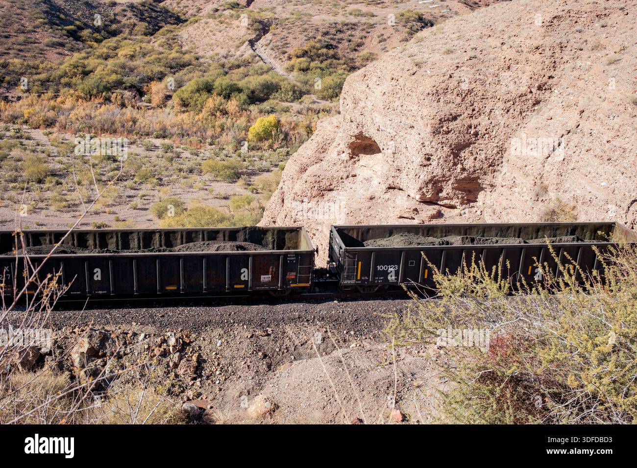 Railroad gondolas hauling raw materials in desert environment Stock ...