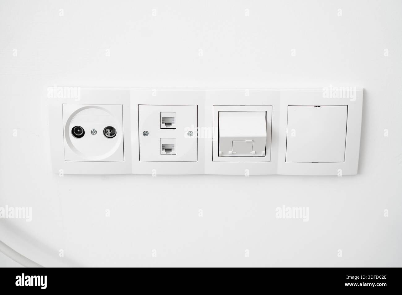 Wall-mounted electrical outlets and network sockets on white wall ...
