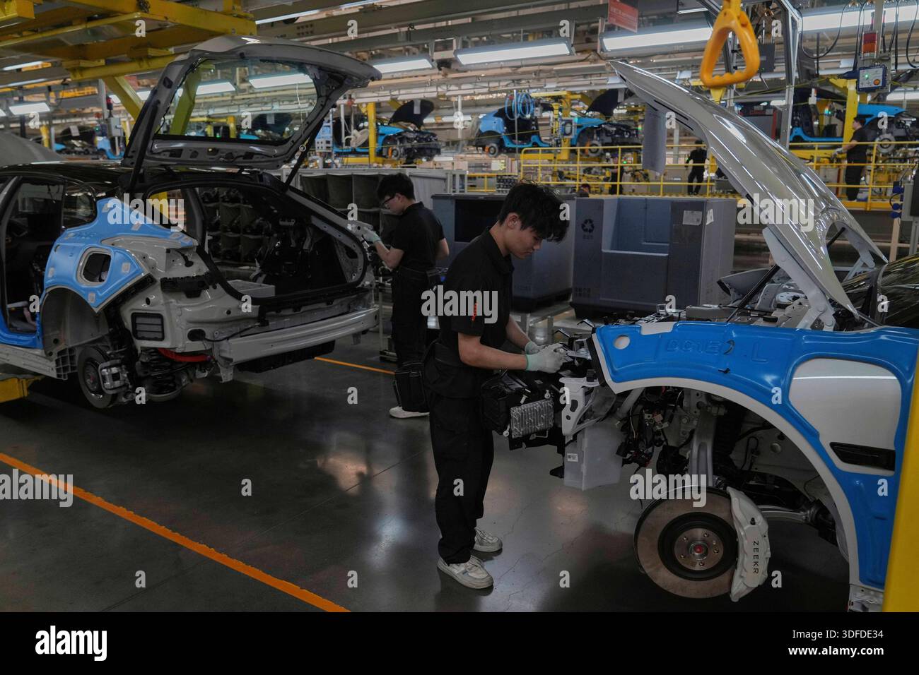 FILE - Workers assemble the Zeekr 001 EV models at the Chinese ...