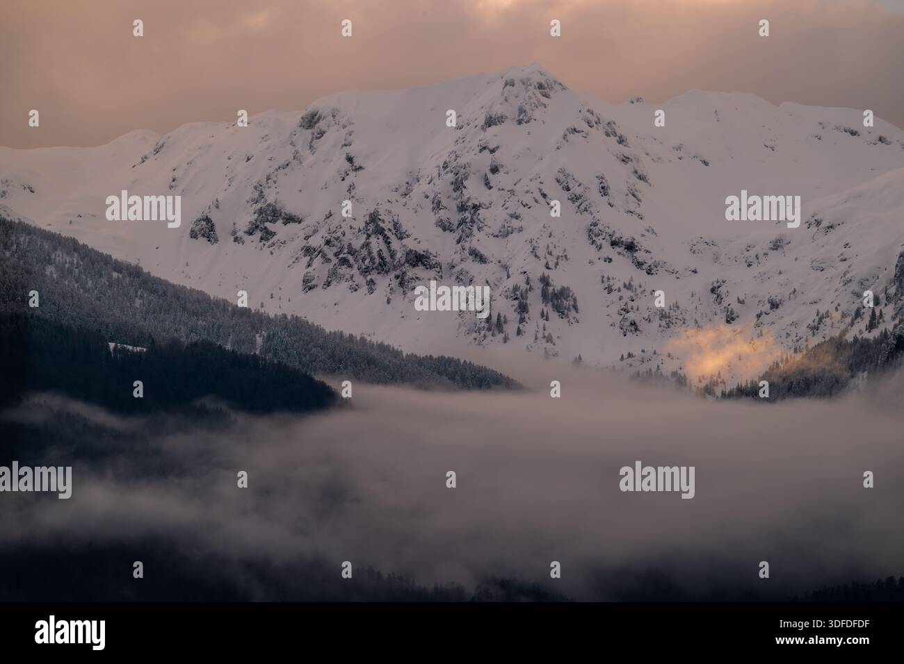 High-altitude shot of snow-capped peaks above a thick layer of valley ...