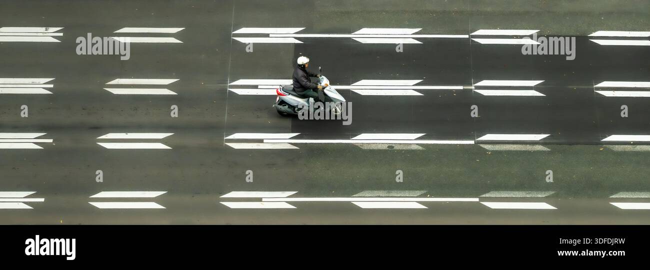 Hakata, Japan - 02 December 2025: Aerial view of a lone scooterist ...