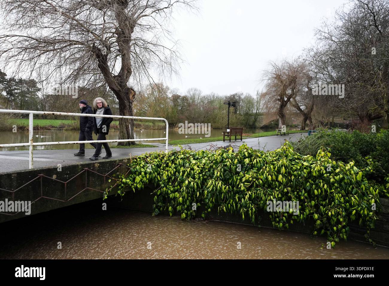 People walk in St Nicholas' Park in Warwick. Heavy rain and melting ...