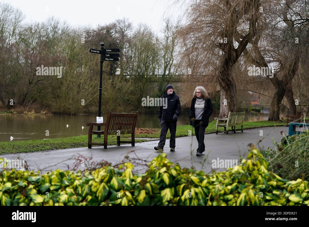 People walk in St Nicholas' Park in Warwick. Heavy rain and melting ...