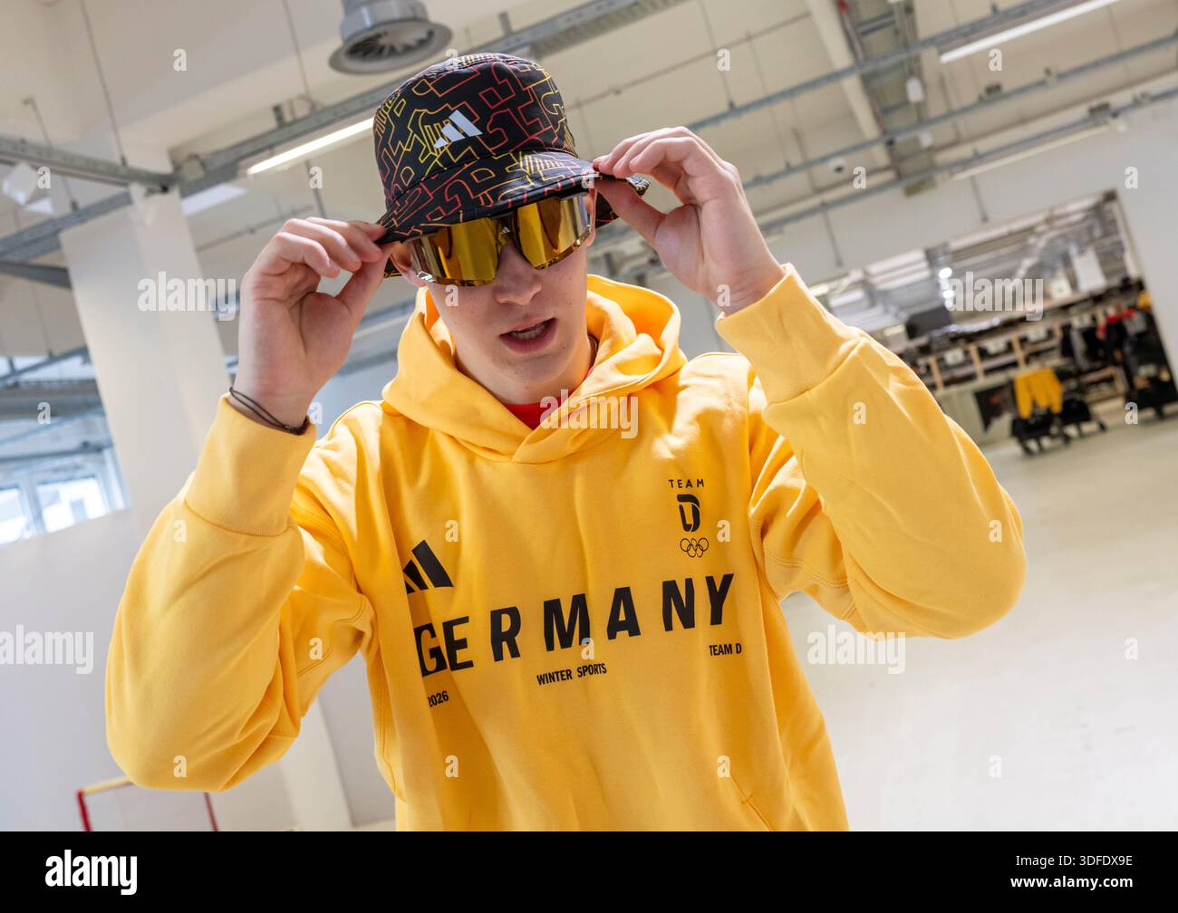 12 January 2026, Bavaria, Munich: Bobsledder Tim Becker tries on his ...