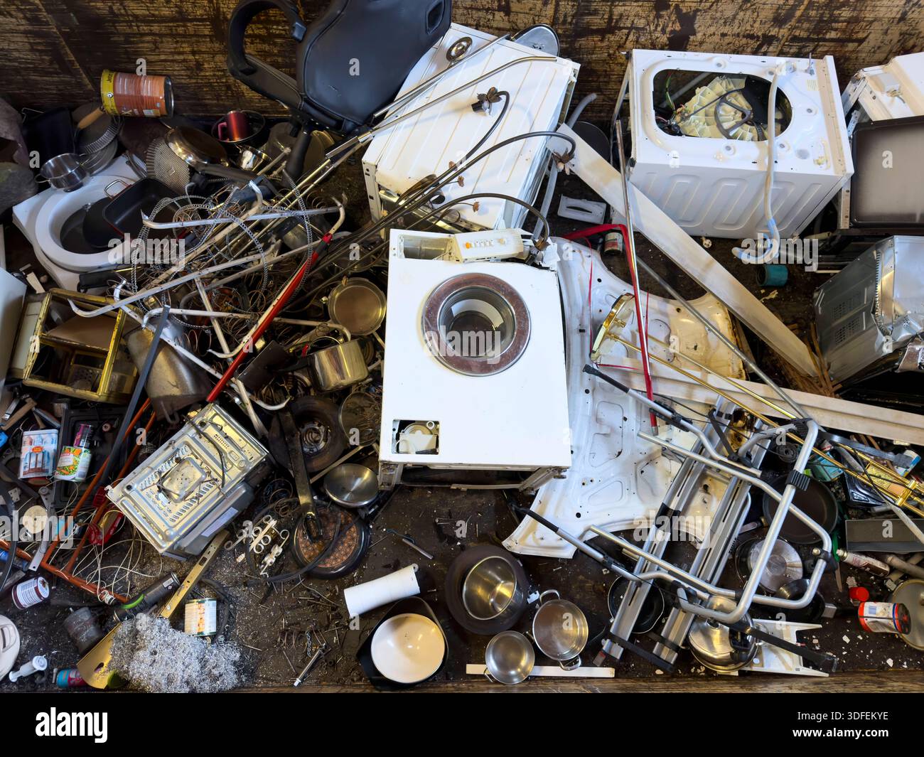 A chaotic heap of discarded white goods, metal cookware, wires, and ...