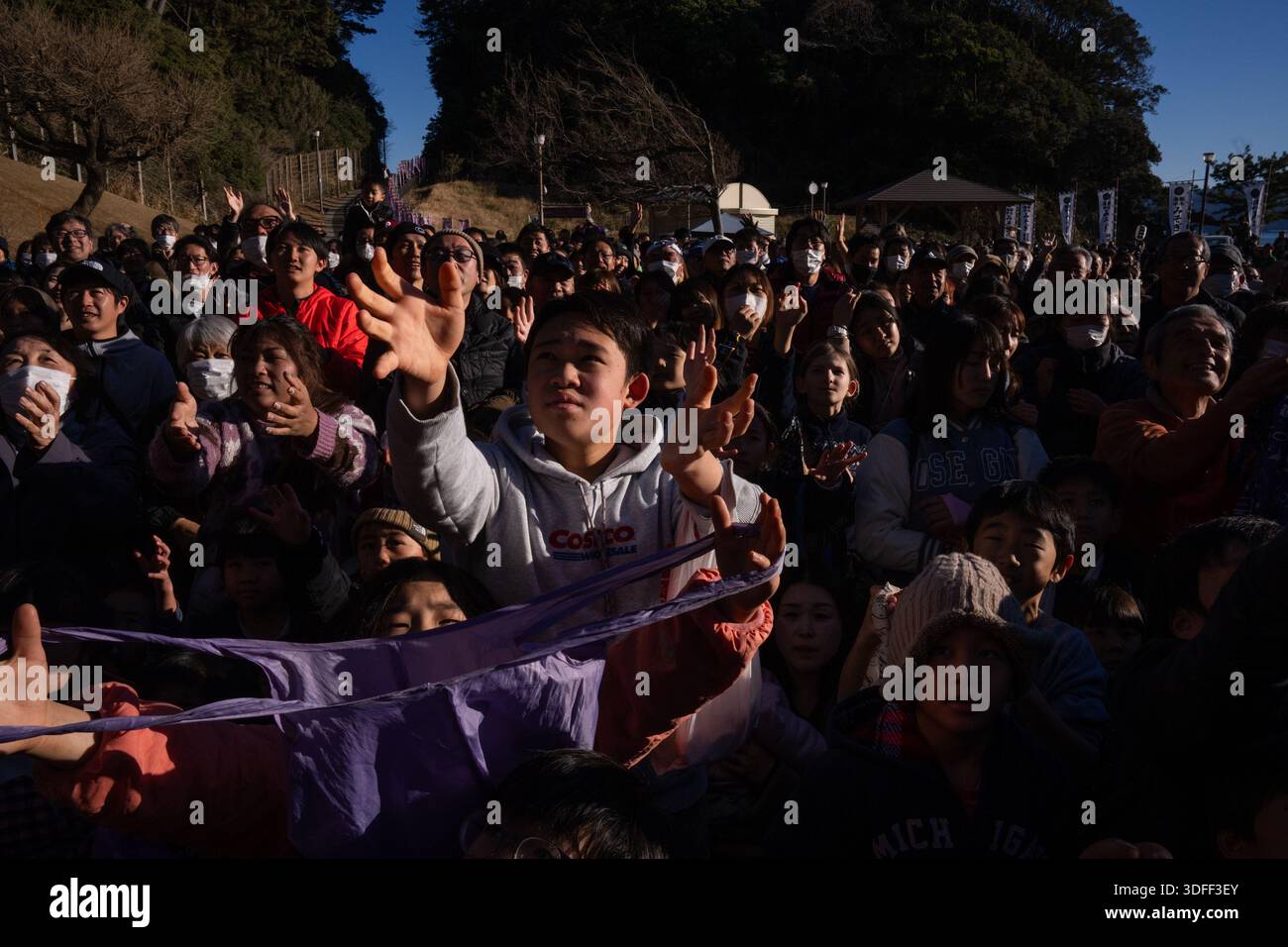 Members of the public try to catch rice cakes thrown after the Winter ...