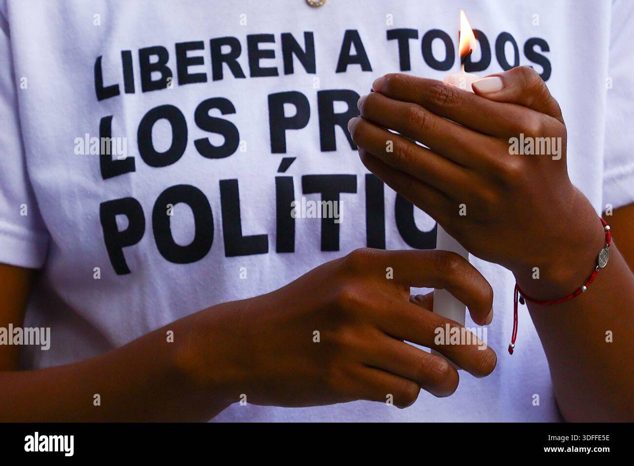 09 January 2026, Venezuela, Caracas: A woman holds a candle during a ...