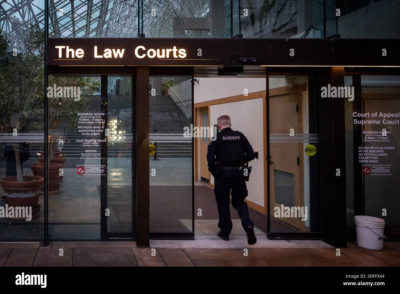 A sheriff enters the Law Courts building, which is home to B.C. Supreme ...